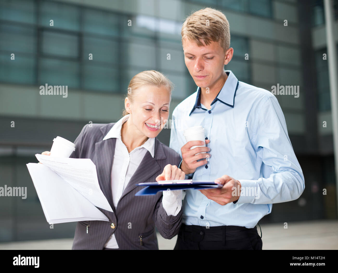 Businesswoman with her employee are reading documents before signing ...