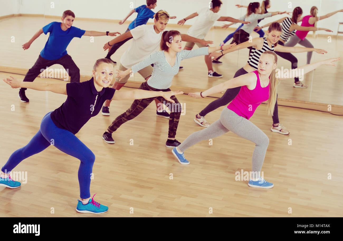 Female trainer holds training session with school children in dance ...