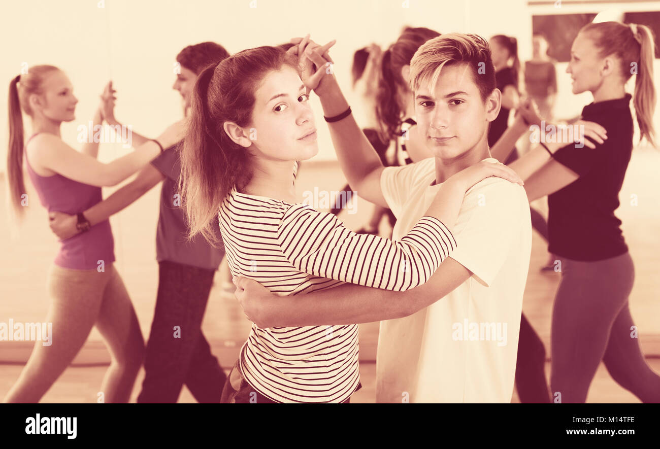 Positive couple of teenagers having dancing class in ballet studio ...