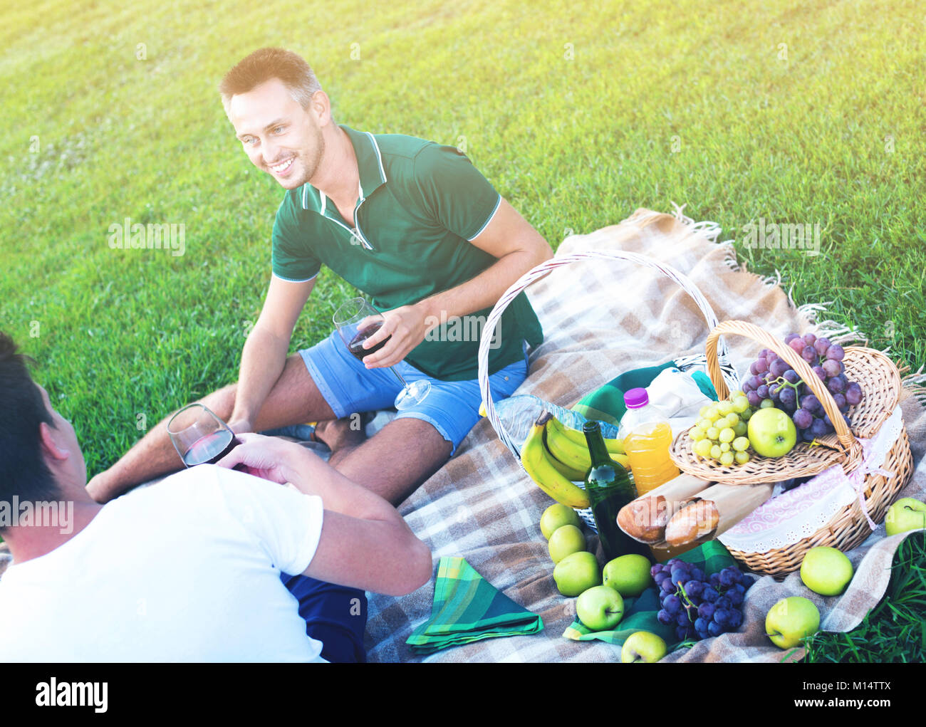 Happy cheerful man enjoying life on picnic outdoors with his friend ...