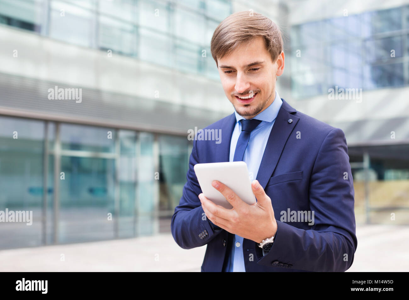 Happy positive male testing digital tablet and touchscreen in the big ...