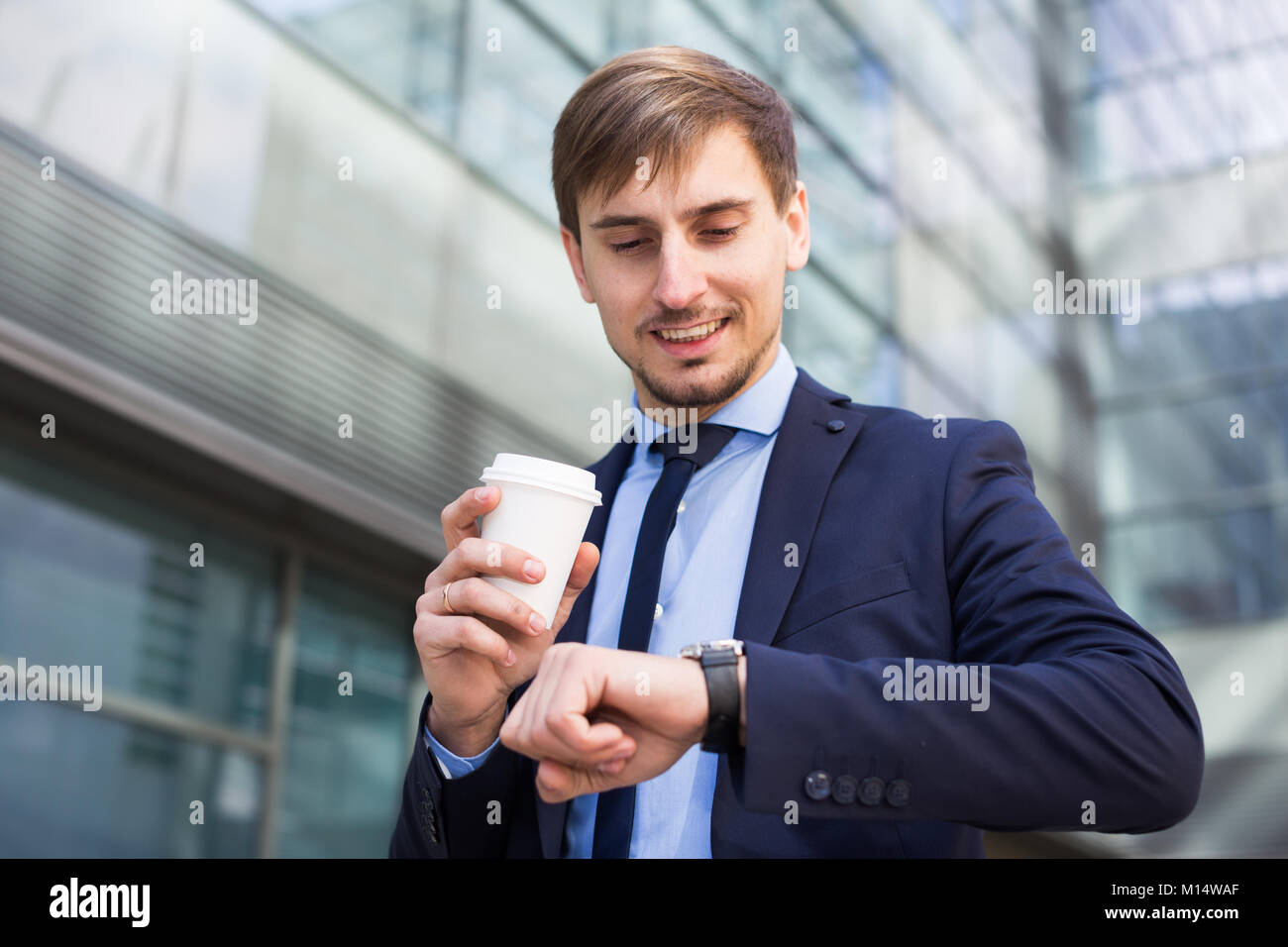 Portrait of cheerful male standing outdoor drinking coffee Stock Photo ...