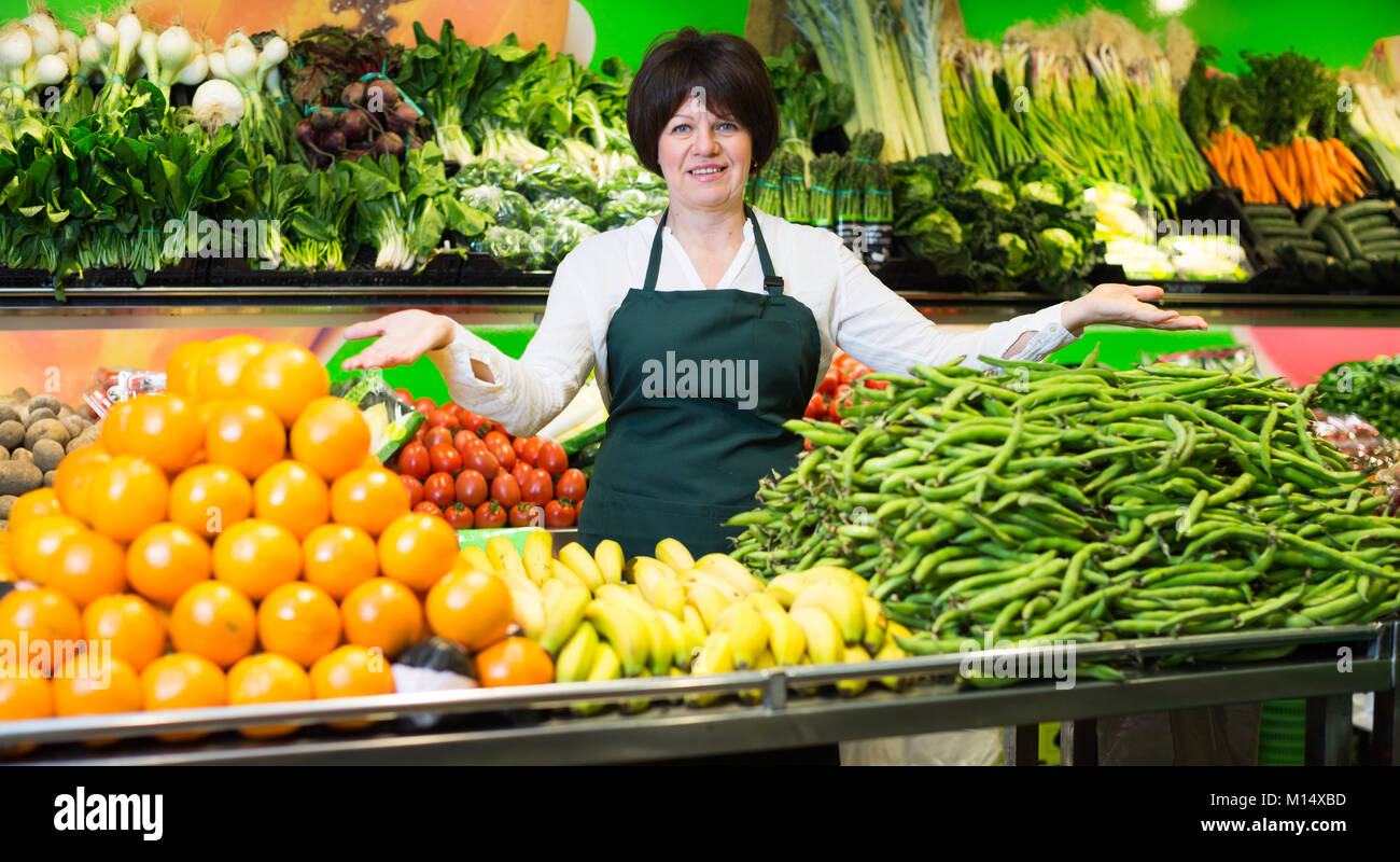 Portrait of adult female selling fruits and vegetables on the store ...