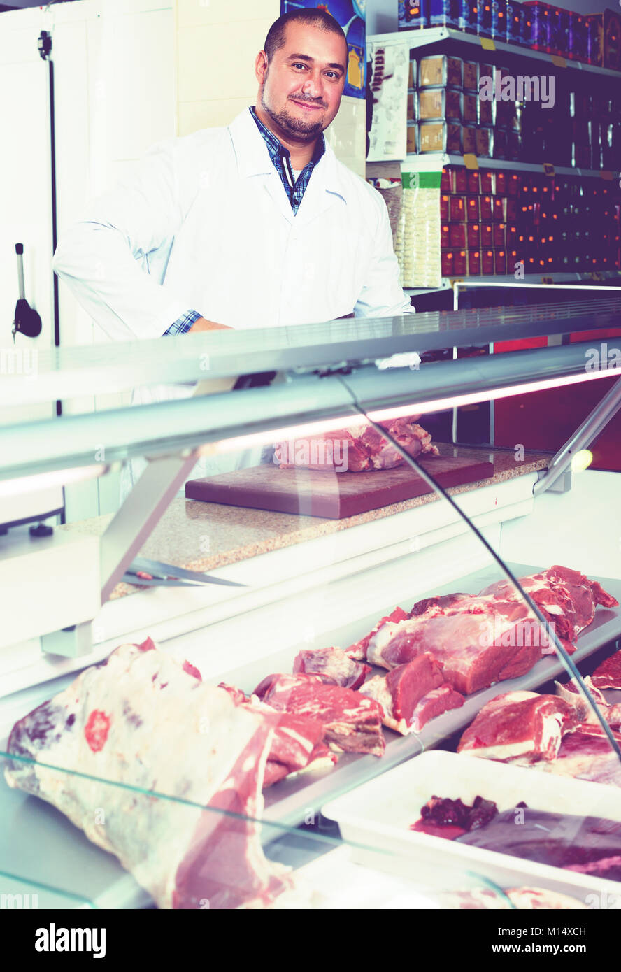 Professional smiling butcher cutting fresh lamb meat in workshop Stock ...