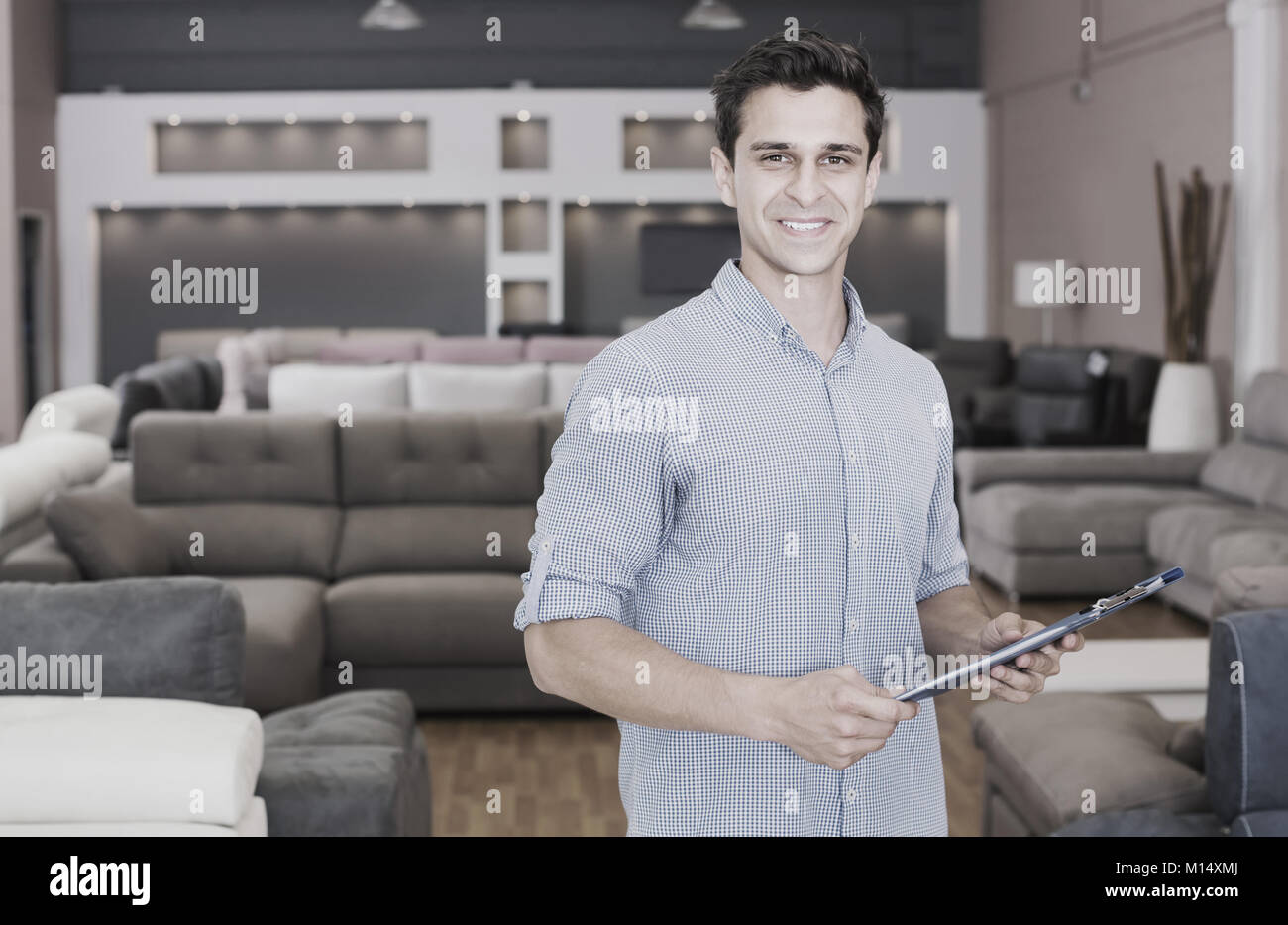 Salesman showing prices in home furnishings store Stock Photo - Alamy