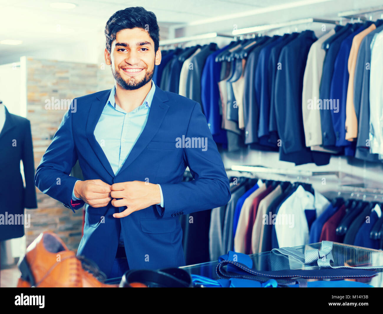 Adult guy is trying on jacket in the shop Stock Photo - Alamy