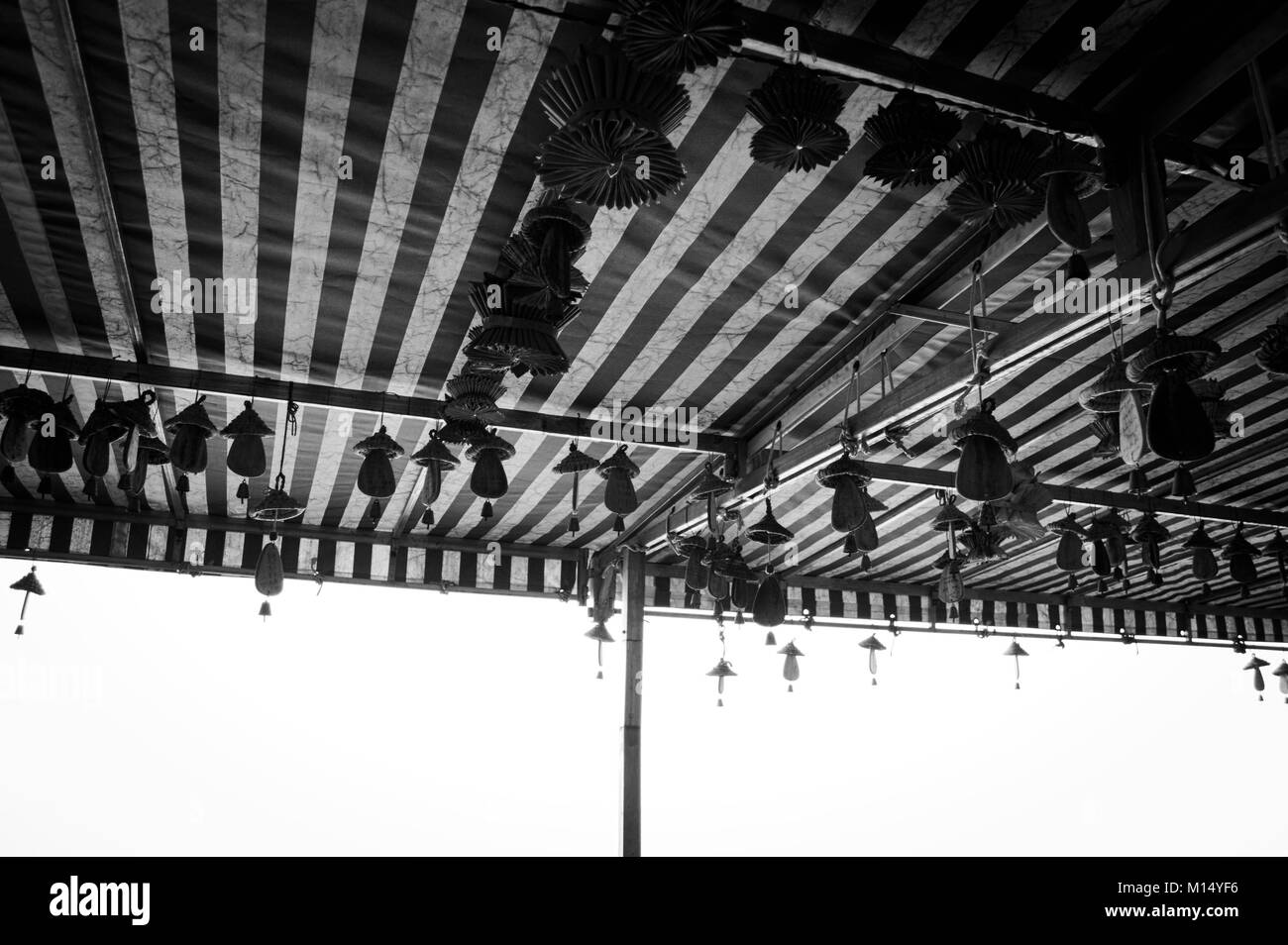 Wooden chinese objects hanging from the striped ceiling (Kunming ...