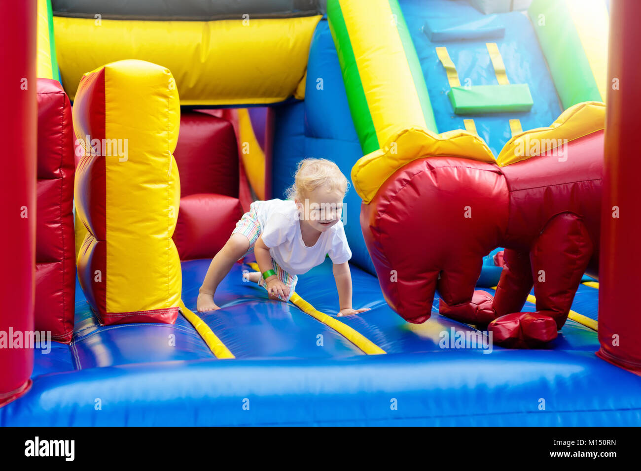 Child jumping on colorful playground trampoline. Kids jump in ...