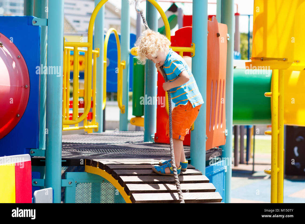 Kids climbing and sliding on outdoor playground. Children play in sunny ...