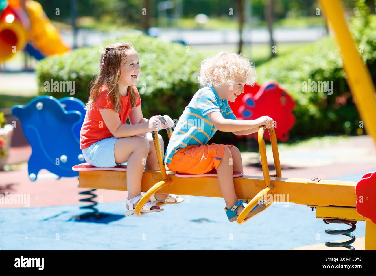 Kids climbing and sliding on outdoor playground. Children play in sunny ...