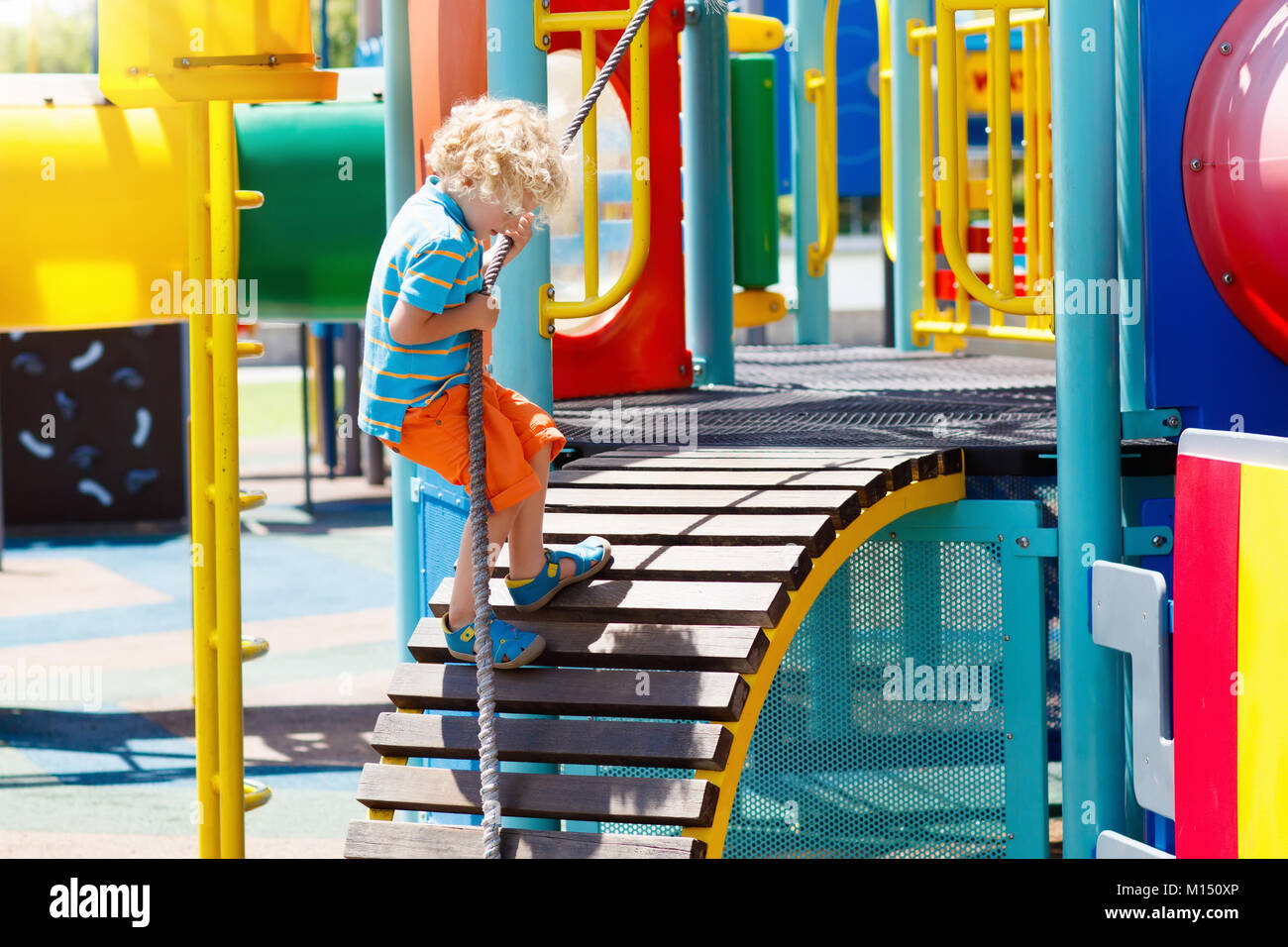 Kids climbing and sliding on outdoor playground. Children play in sunny ...
