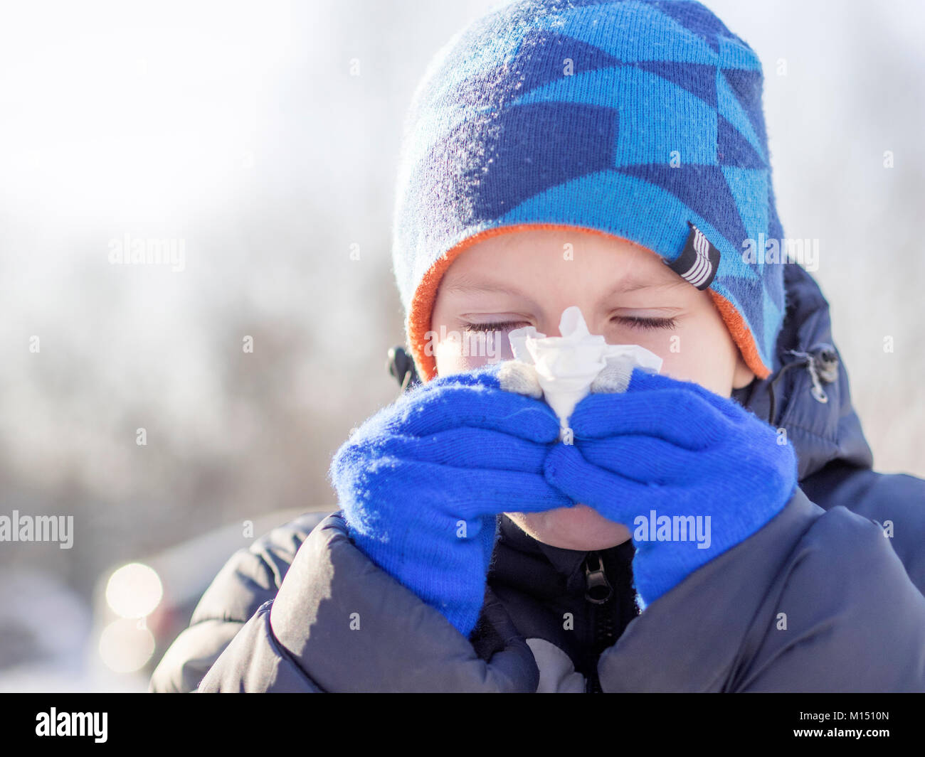 Caucasian boy blows his nose into a paper handkerchief Stock Photo - Alamy