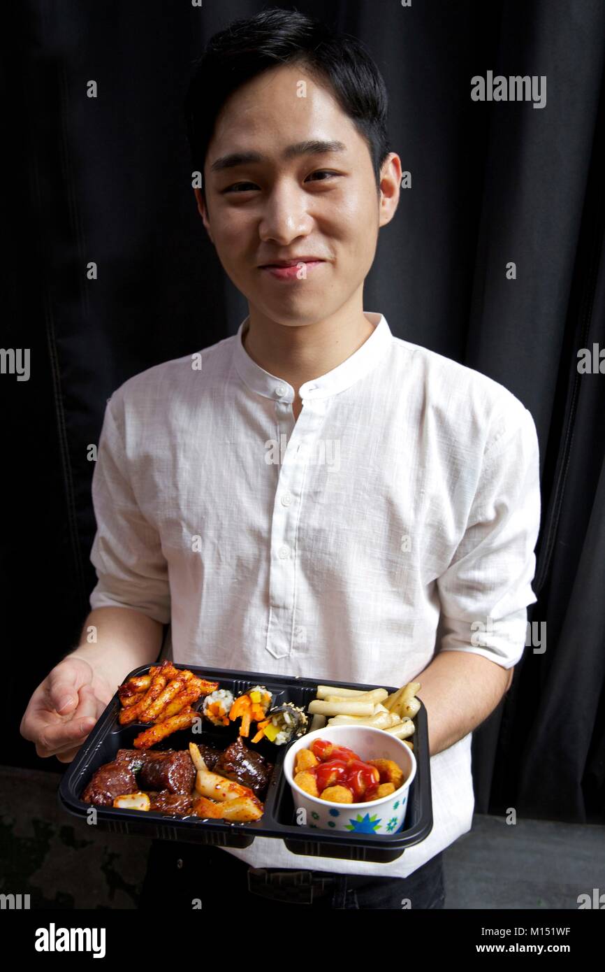 South Korea, Seoul, young man with tray with korean dishes in the Tong ...