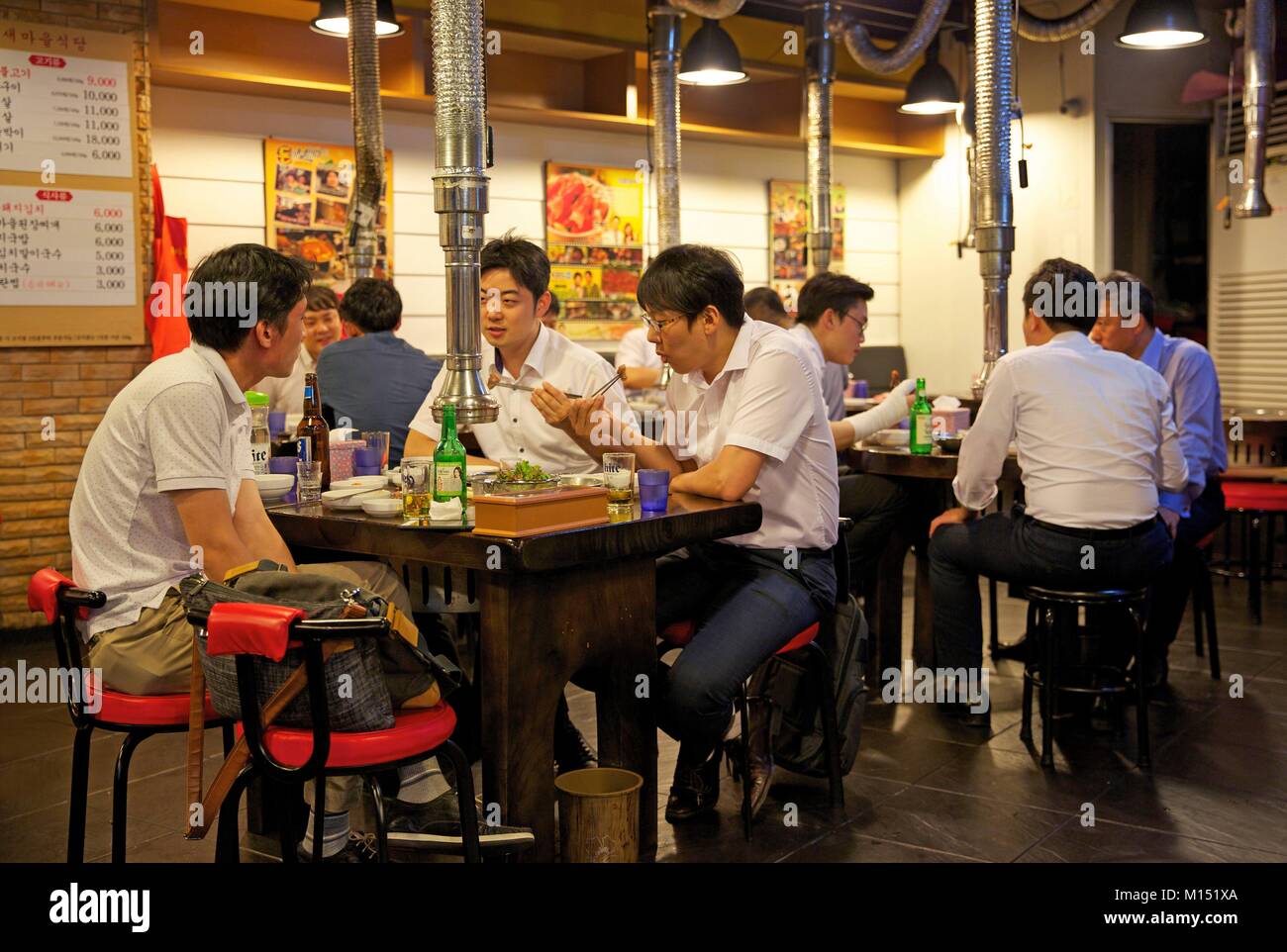 South Korea, Seoul, working men sitting in a korean barbecue restaurant ...