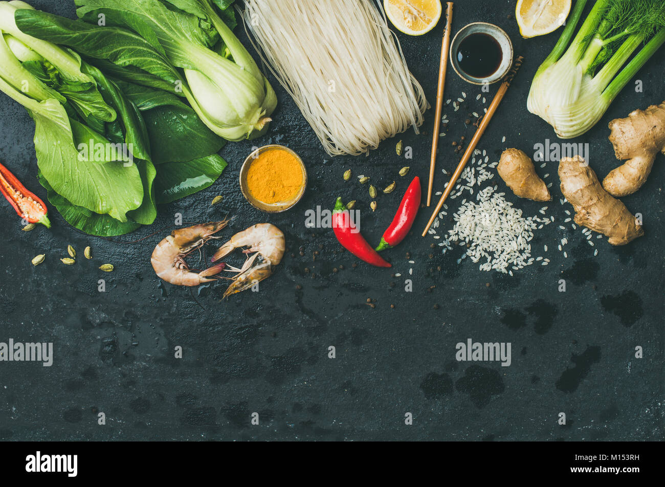 Asian cuisine ingredients over black background, top view, copy space ...
