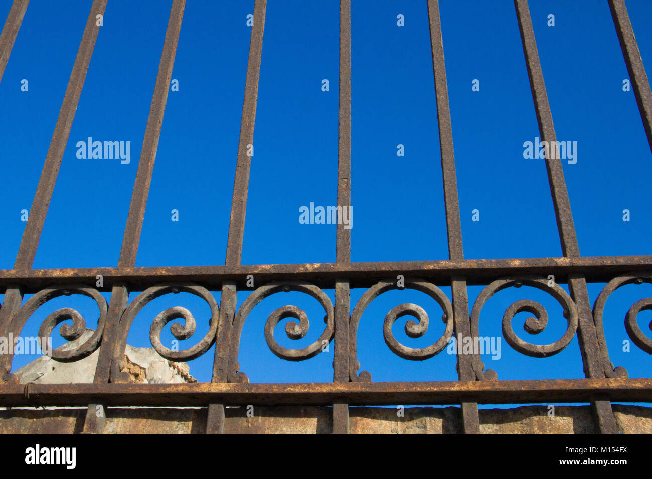 A rusty wrought iron gate against a blue sky Stock Photo - Alamy