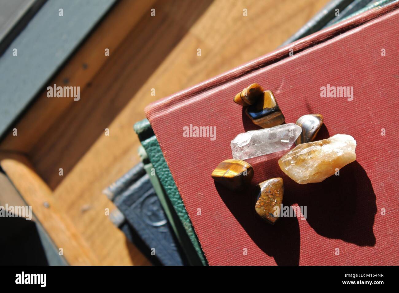 crystals and gemstones on a stack of old books Stock Photo - Alamy