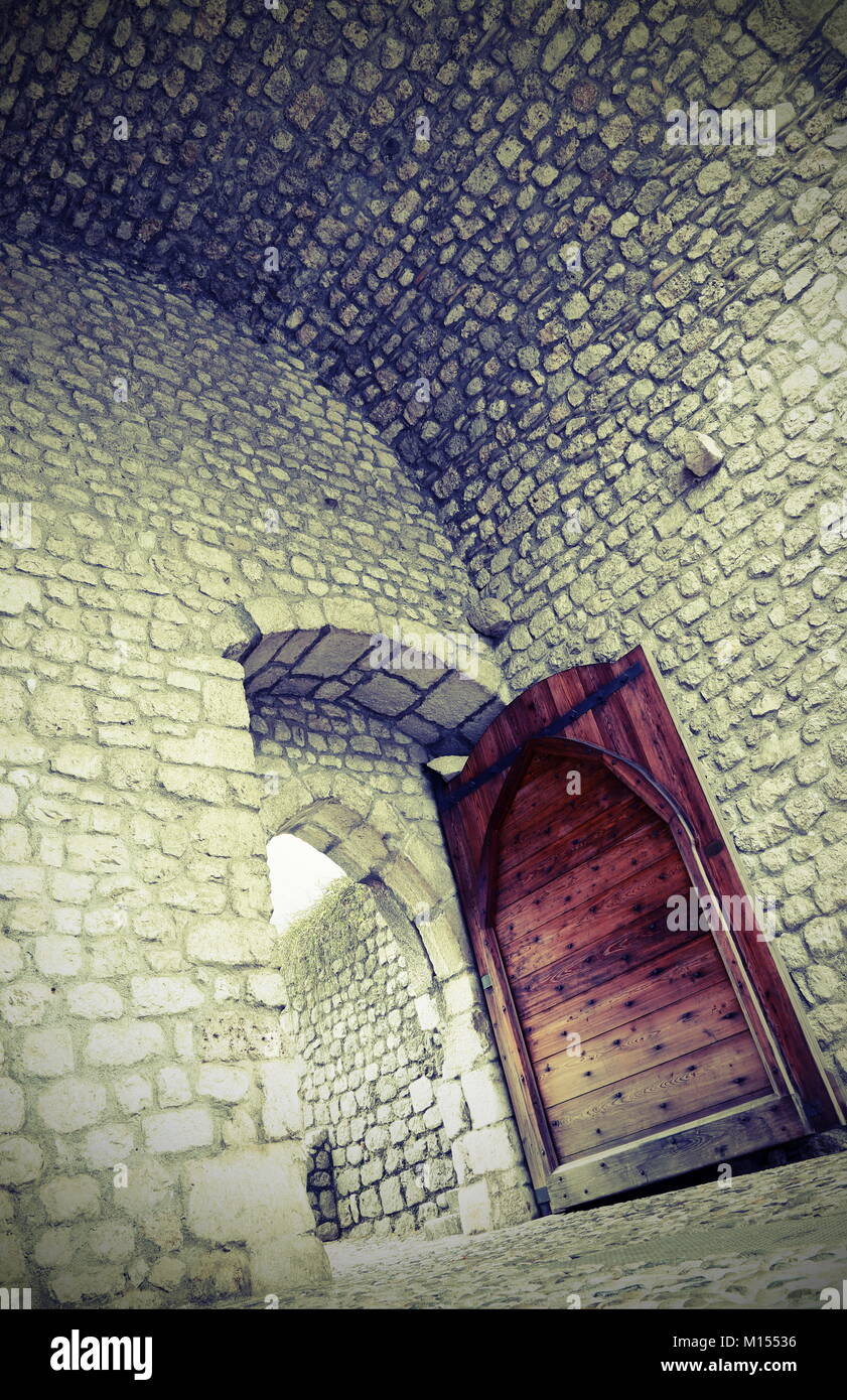 large wooden gate in the medieval castle walls with vintage effect ...