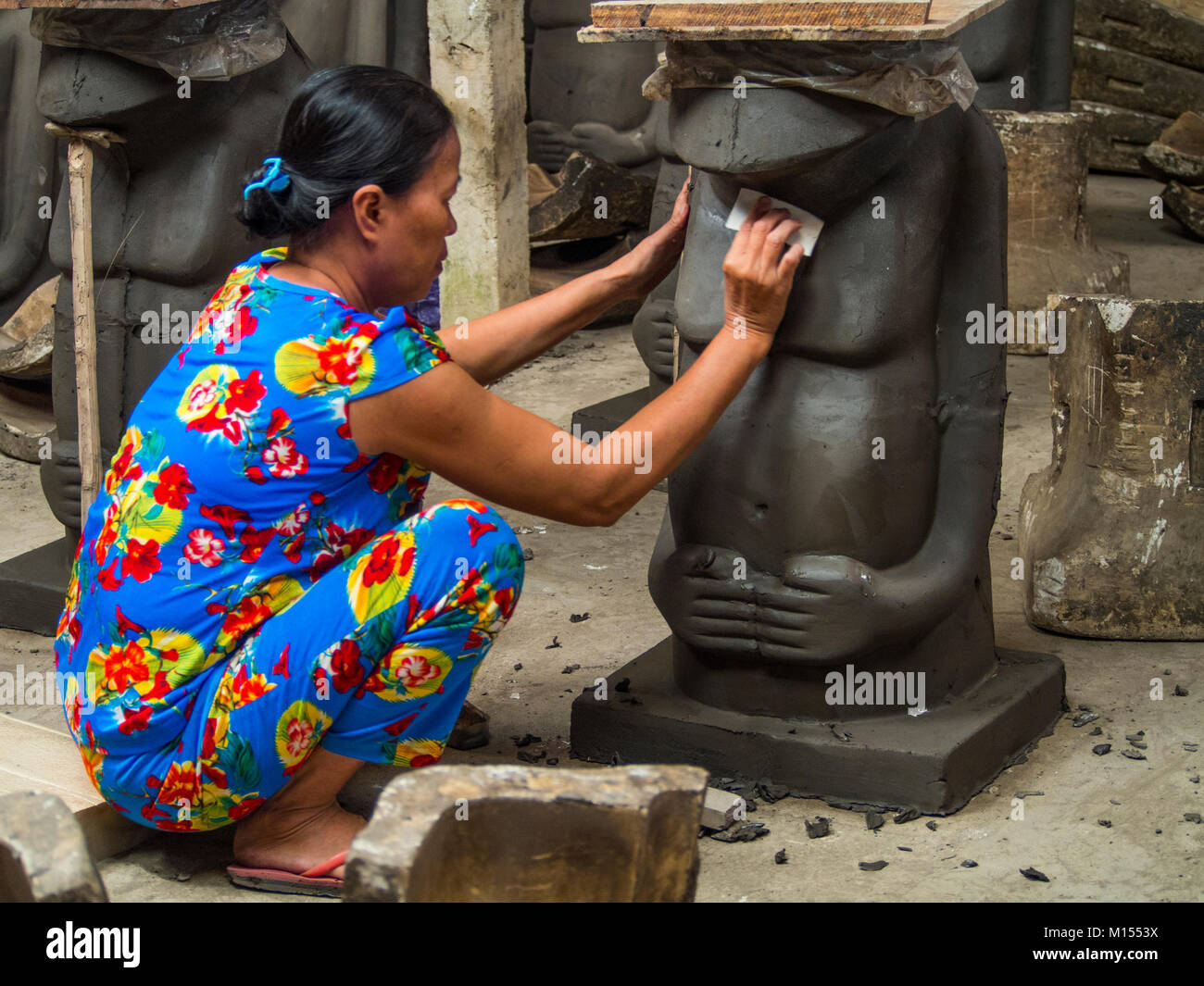 Mekong delta, Vietnam - December 15, 2017 Woman making a moai statue ...