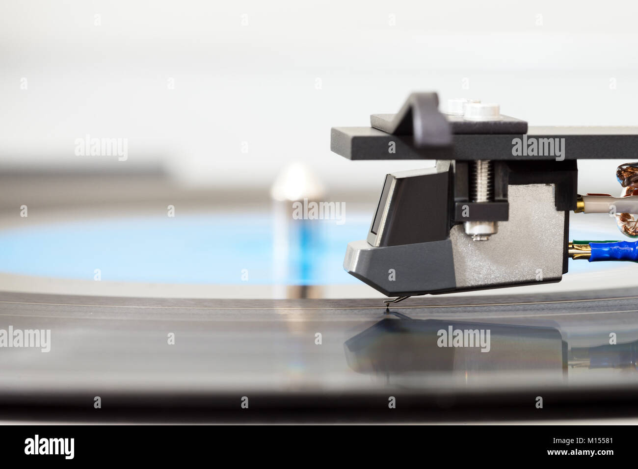 Stylus on vinyl record. Close up of turntable cartridge with needle and ...