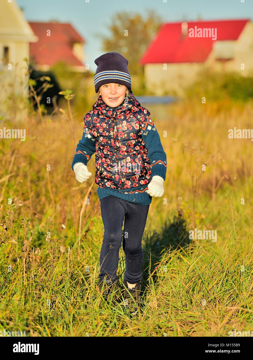 Laughing Happy little girl running in sunlight on autumn meadow Stock ...