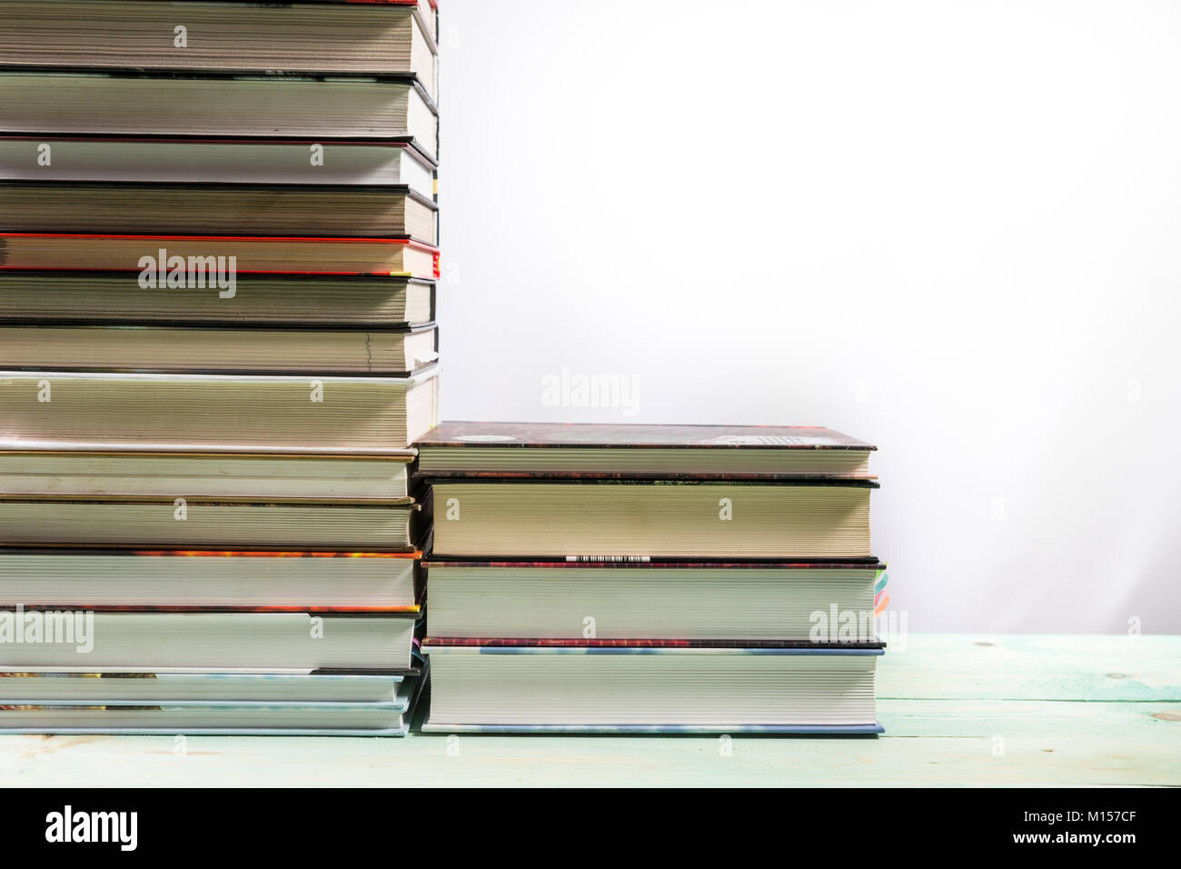 Pile of various books on bright wooden background. With copy space for ...