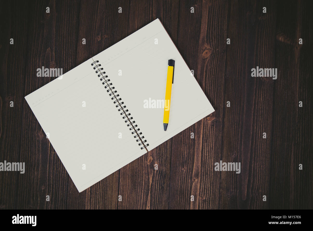 Notebook and empty white paper with pen on wood table top view with ...
