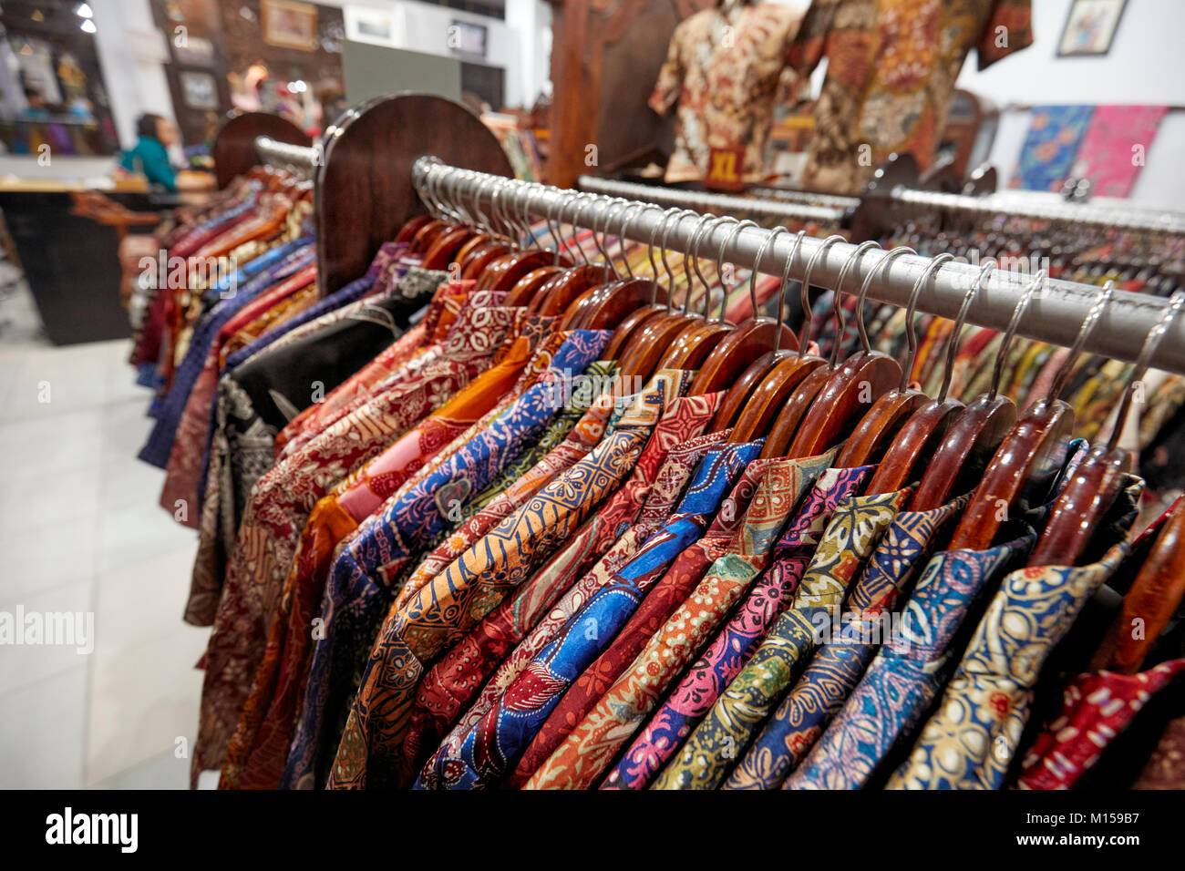 Colorful silk batik shirts on a rack in Hamzah Batik shop. Yogyakarta ...