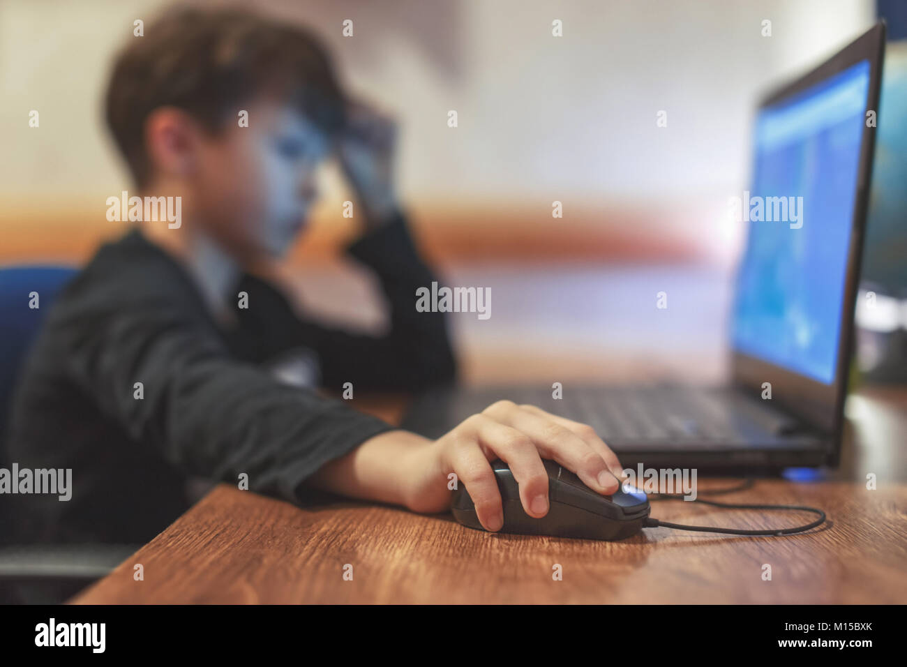 Little addicted boy playing video game on laptop at home Stock Photo ...