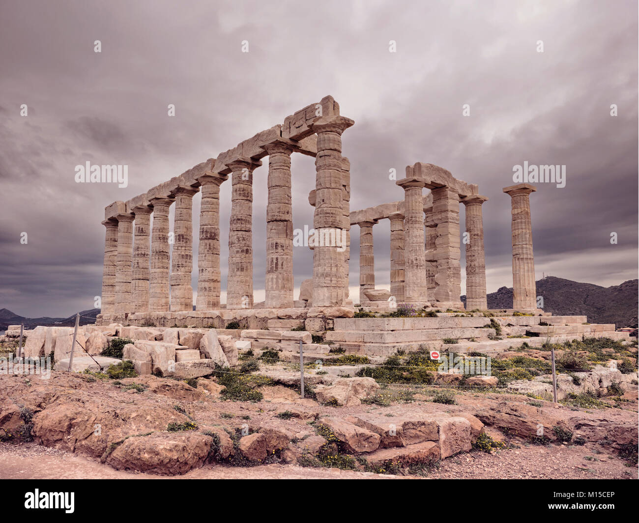 Ruins of an ancient Greek temple of Poseidon under dramatic cloudy sky ...