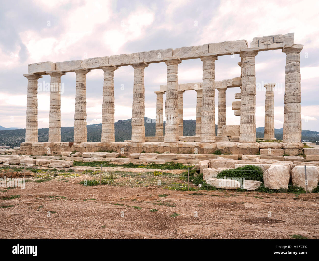 Ruins of an ancient Greek temple of Poseidon under dramatic cloudy sky ...