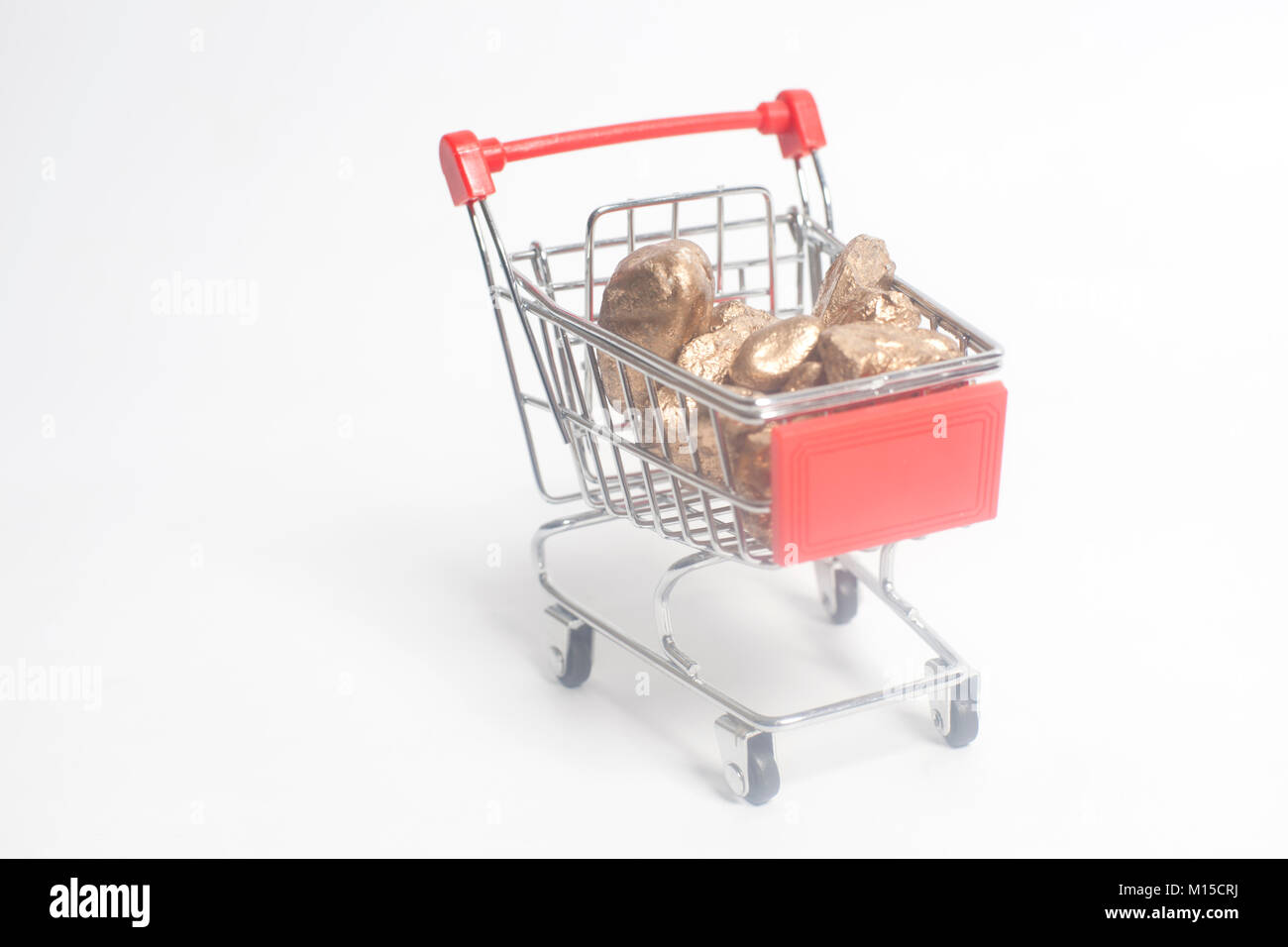 Shopping cart with gold nuggets on white Stock Photo - Alamy