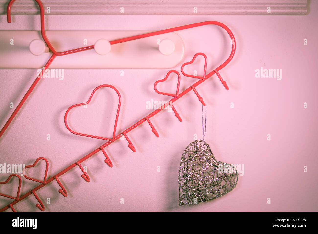 Pink Heart clothes hanger and heart shape hanger on red background ...