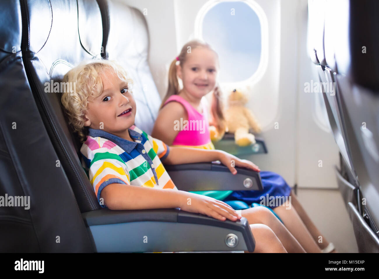 Child in airplane. Kids sit in air plane window seat. Flight ...