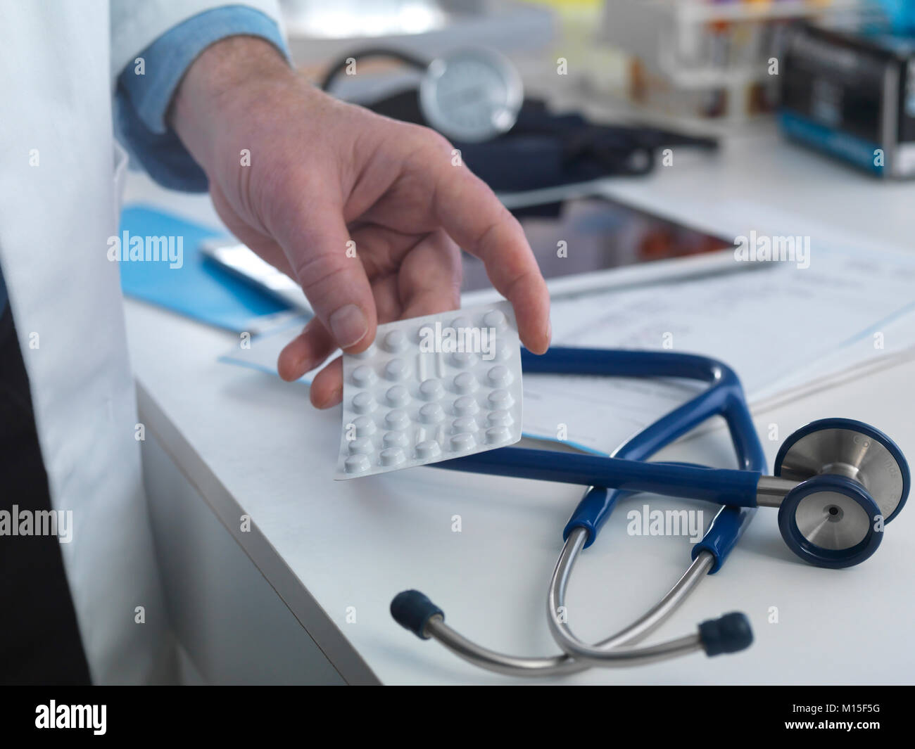 MODEL RELEASED. Doctor holding a strip of drugs ready to hand out to ...