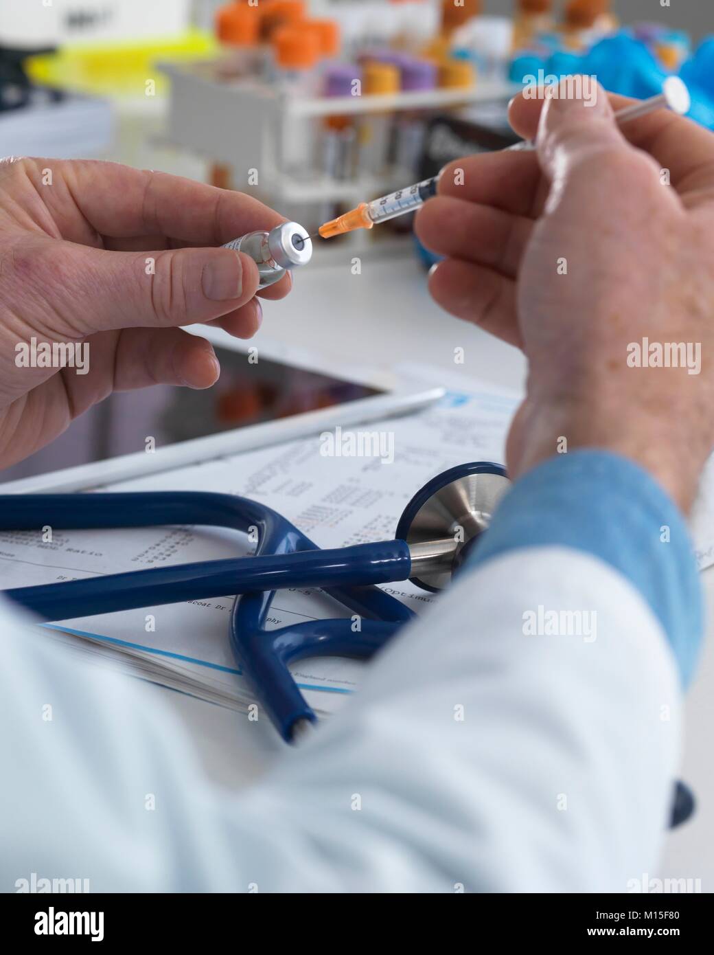 MODEL RELEASED. Doctor preparing a syringe ready for injection Stock ...