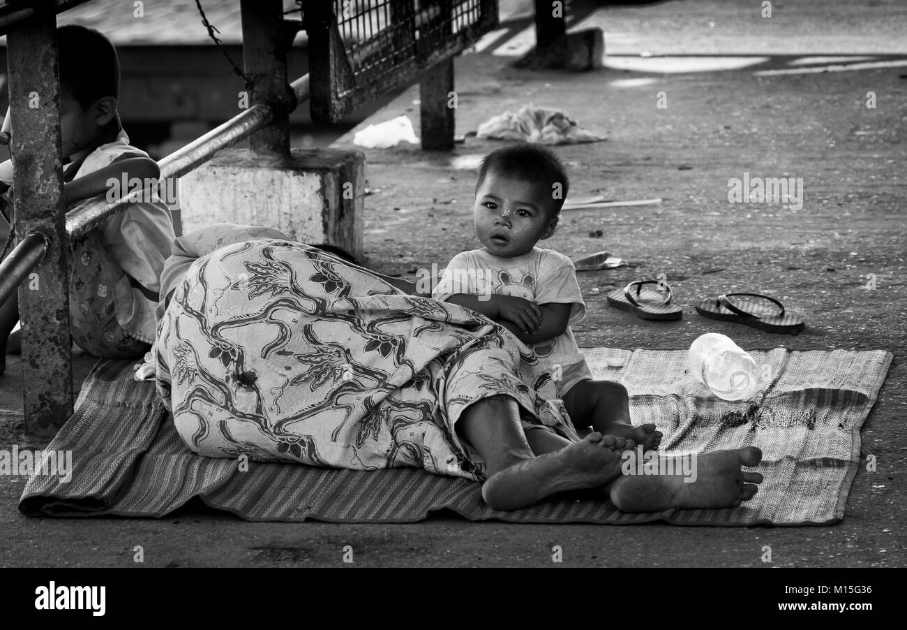 YANGON, MYANMAR - NOVEMBER, 2016: Homeless woman with children resting ...