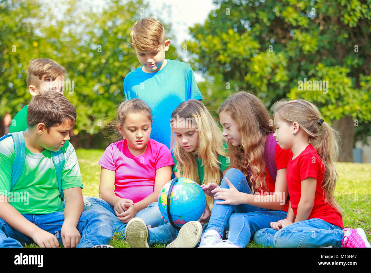 Children with a globe are learning geography at the park Stock Photo ...