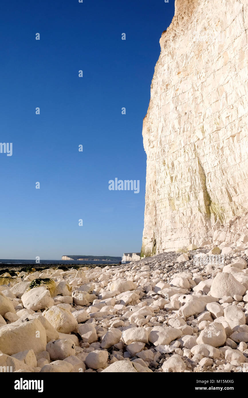 Tall white chalk cliff face with big white chalk boulders that have ...