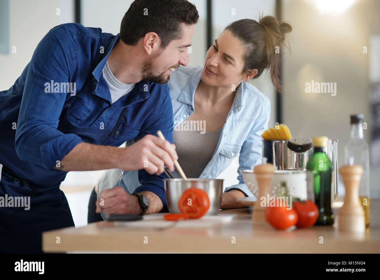 Couple at home having fun cooking together Stock Photo - Alamy
