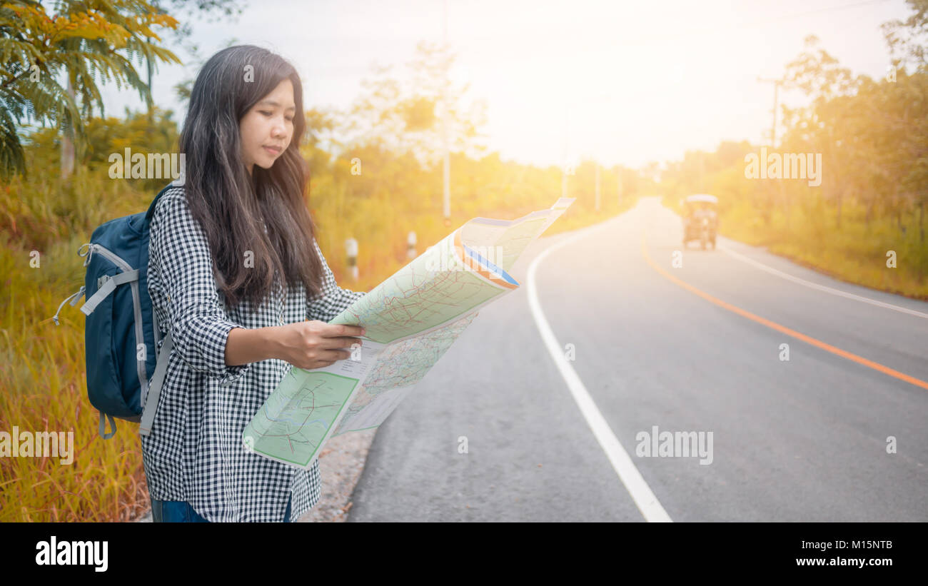 Hipster Asian woman backpacker look map on trip Stock Photo - Alamy