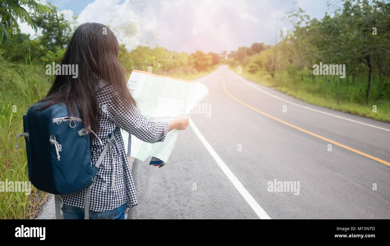 Hipster Asian woman backpacker look map on trip Stock Photo - Alamy