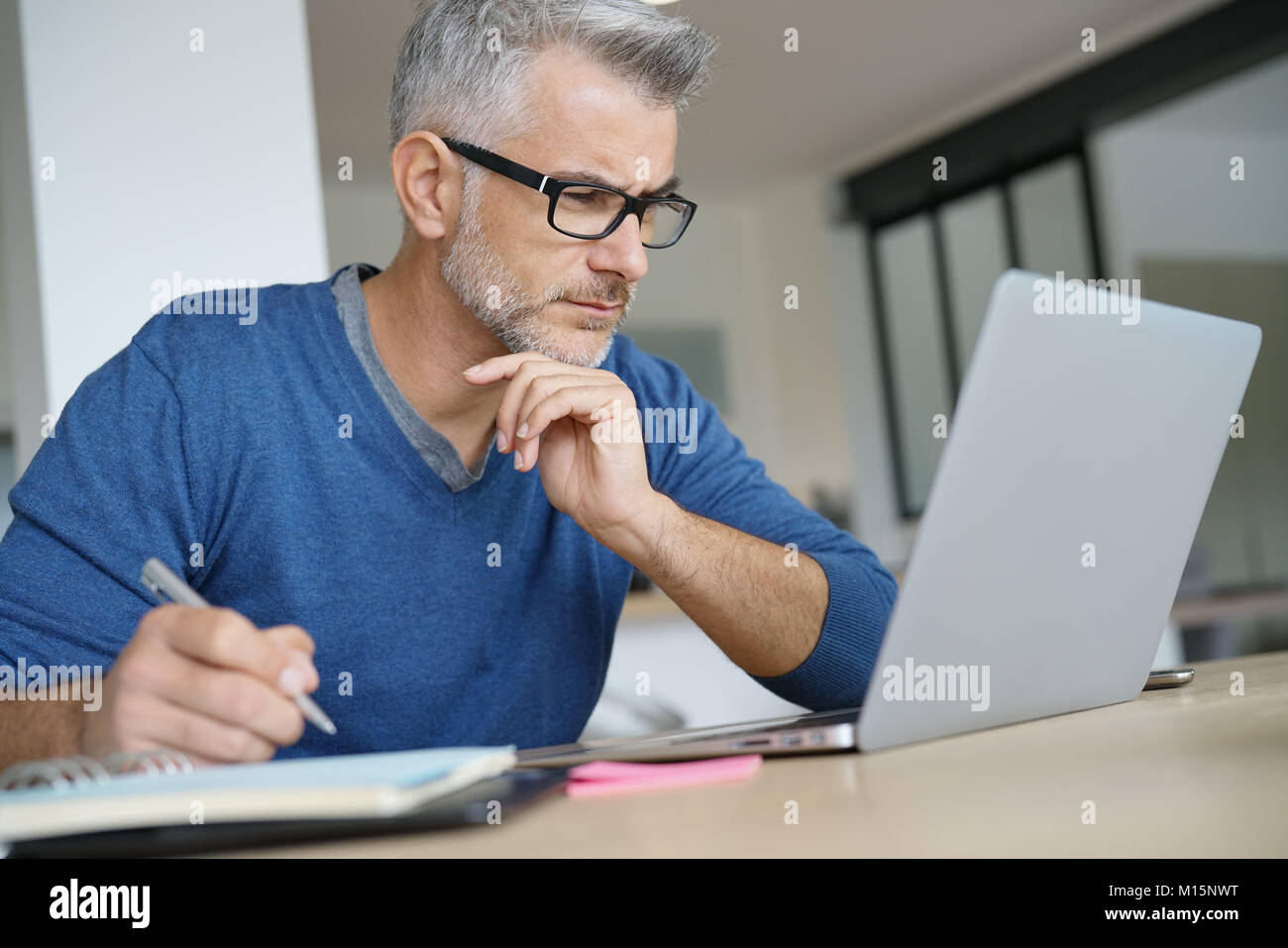 Middle-aged man working from home-office on laptop Stock Photo - Alamy