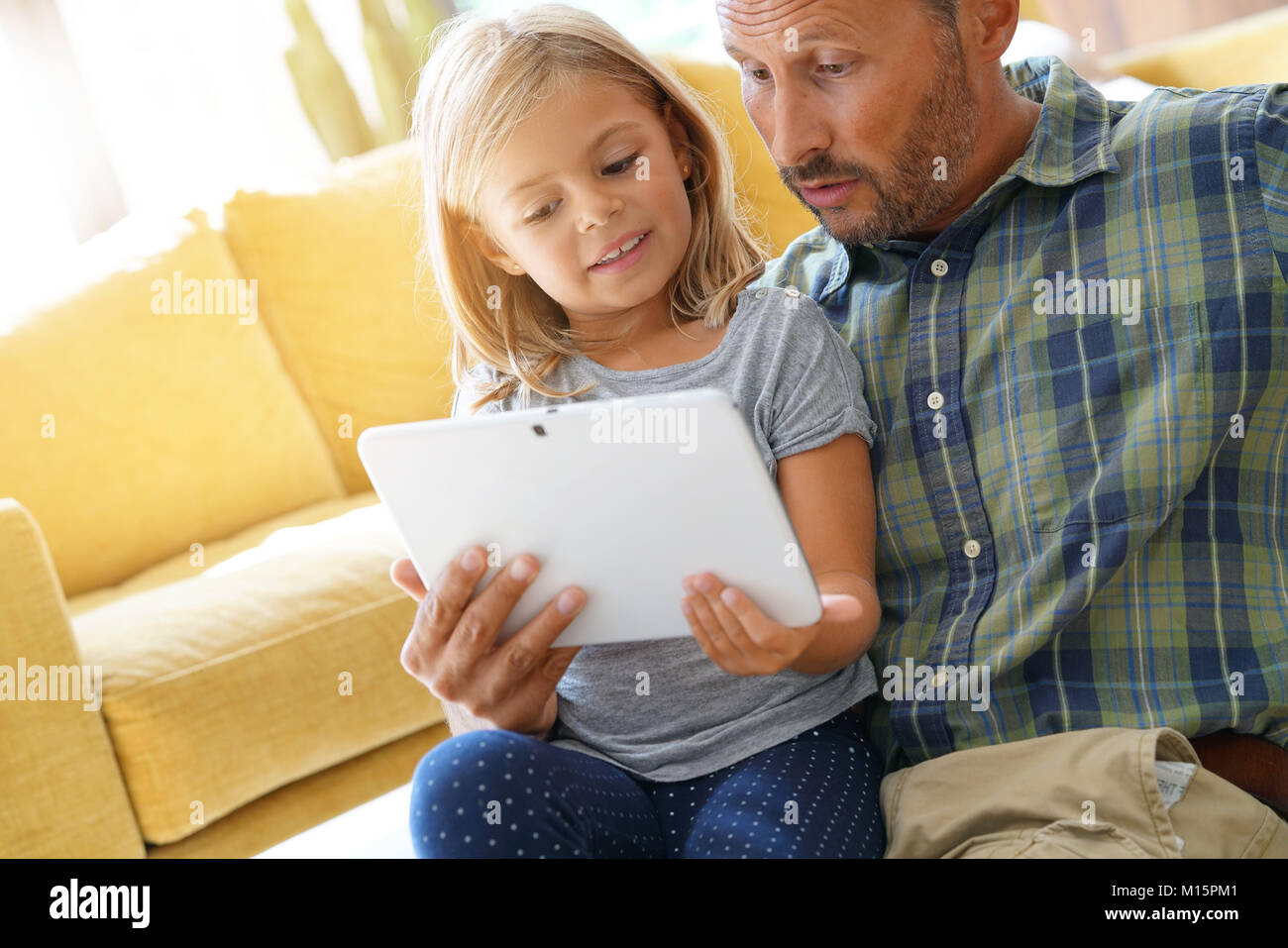 Daddy with little girl connected on digital tablet Stock Photo - Alamy