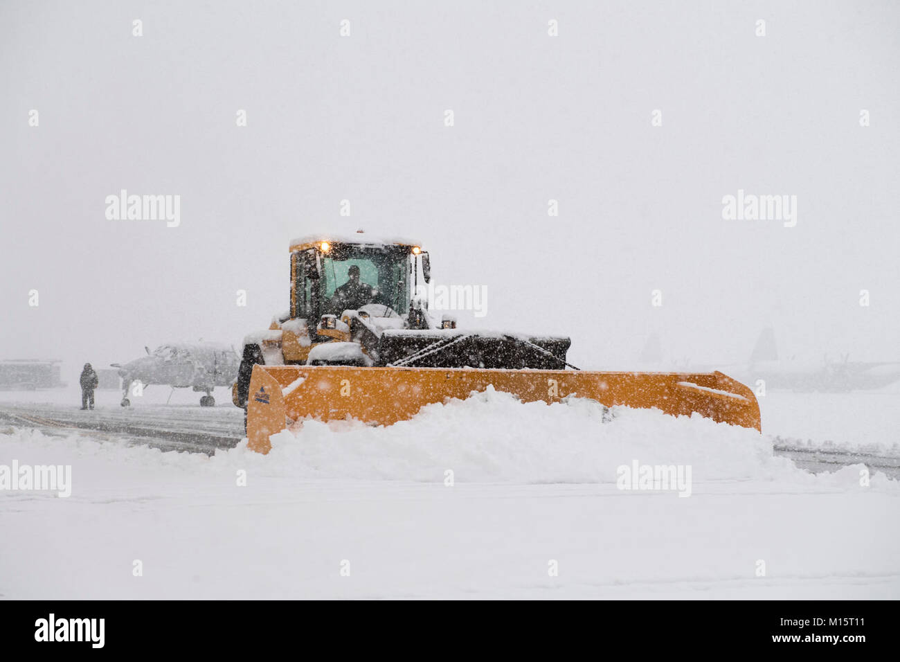 A 374th Civil Engineer Squadron Airman uses a front end loader with a ...