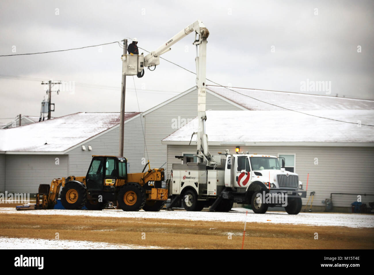 A worker with Xcel Energy takes a look at an electrical connection on a ...