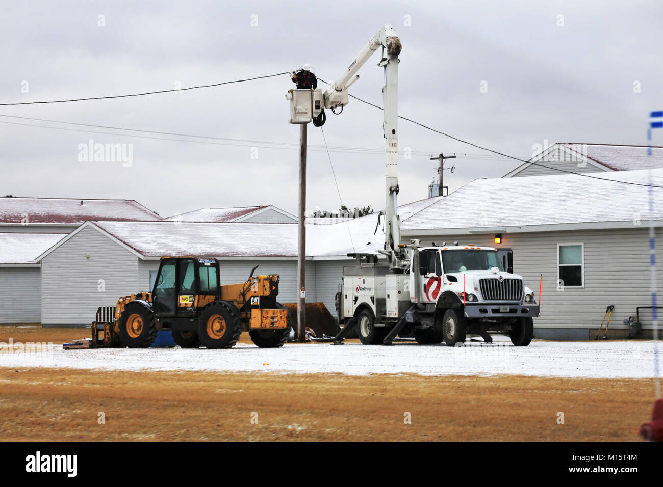 A worker with Xcel Energy takes a look at an electrical connection on a ...