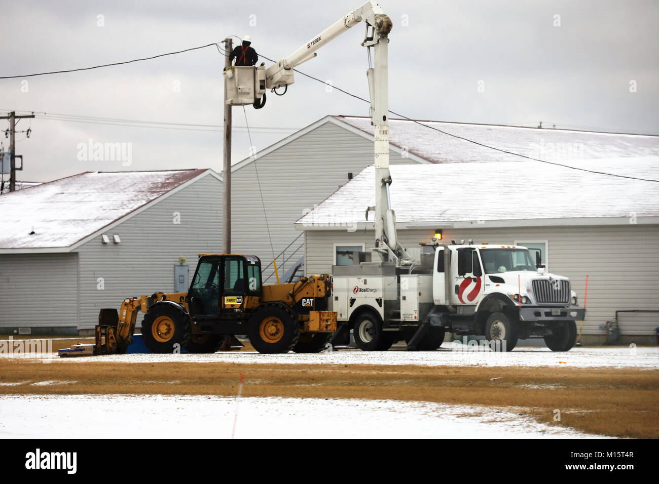 A worker with Xcel Energy takes a look at an electrical connection on a ...