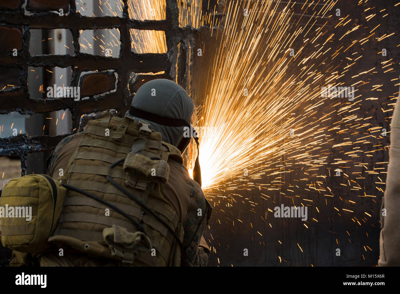 A U.S. Marine attending the Methods of Entry (MOE) course uses a torch ...