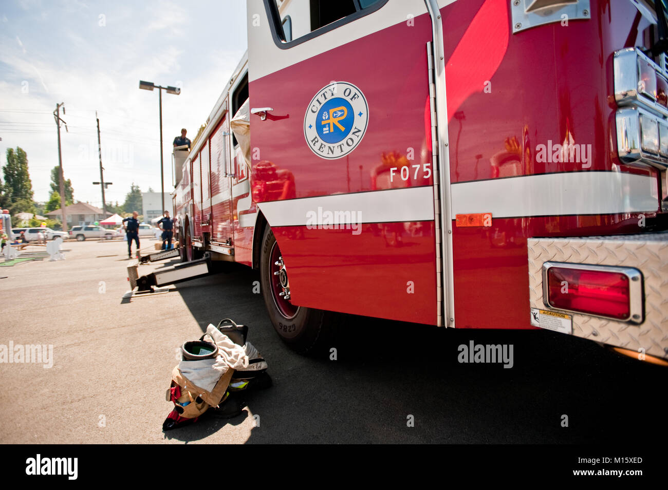 Two fire fighters standing by a fire truck on display hi-res stock ...